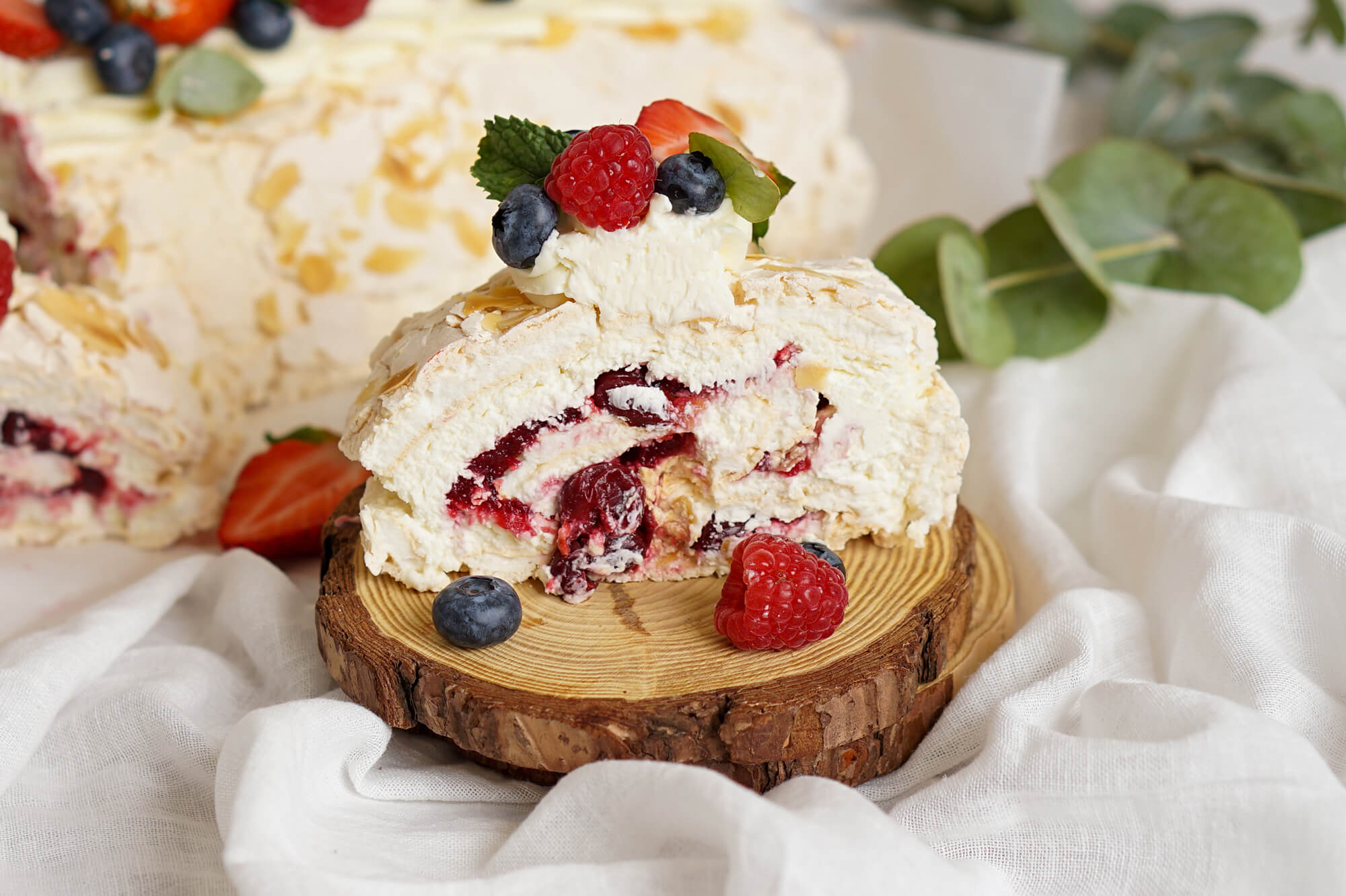 Merengue roll with berries and almond flakes - EVA Cakes
